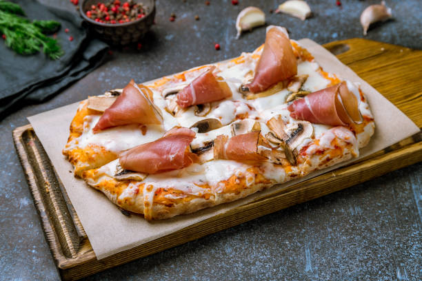 Free Stock Photo of A pizza with different toppings on a paper ...
