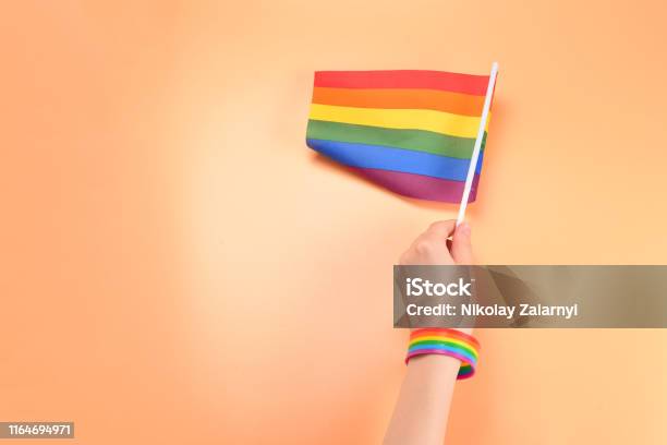 Bendera Lgbt Di Tangan Wanita Dengan Latar Belakang Oranye Salin Ruang