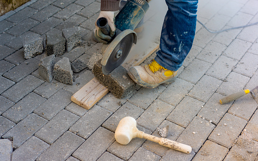 Paving Stone Worker Is Putting Down Pavers During A Construction Of A ... Paving Stone Worker Is Putting Down Pavers During A Construction Of A ...