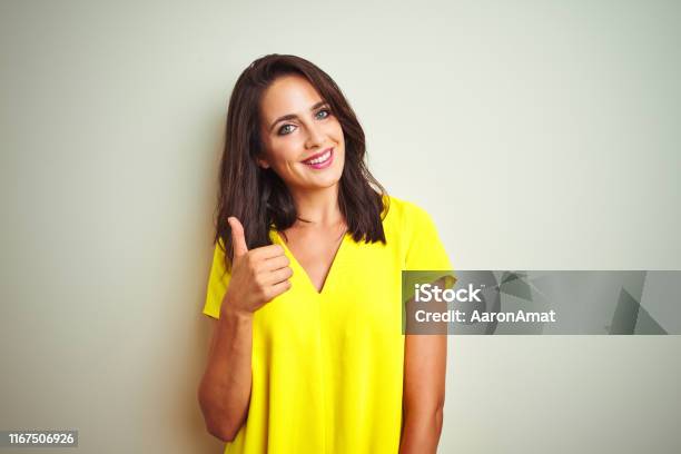 Wanita Cantik Muda Yang Mengenakan Kaos Kuning Berdiri Di Atas Latar