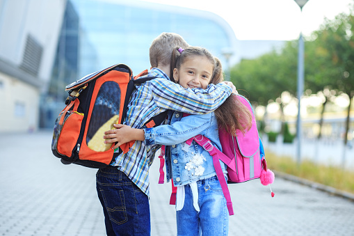 Niños Felices Abrazando Y Riendo Cerca De La Escuela Niño Y Niña El