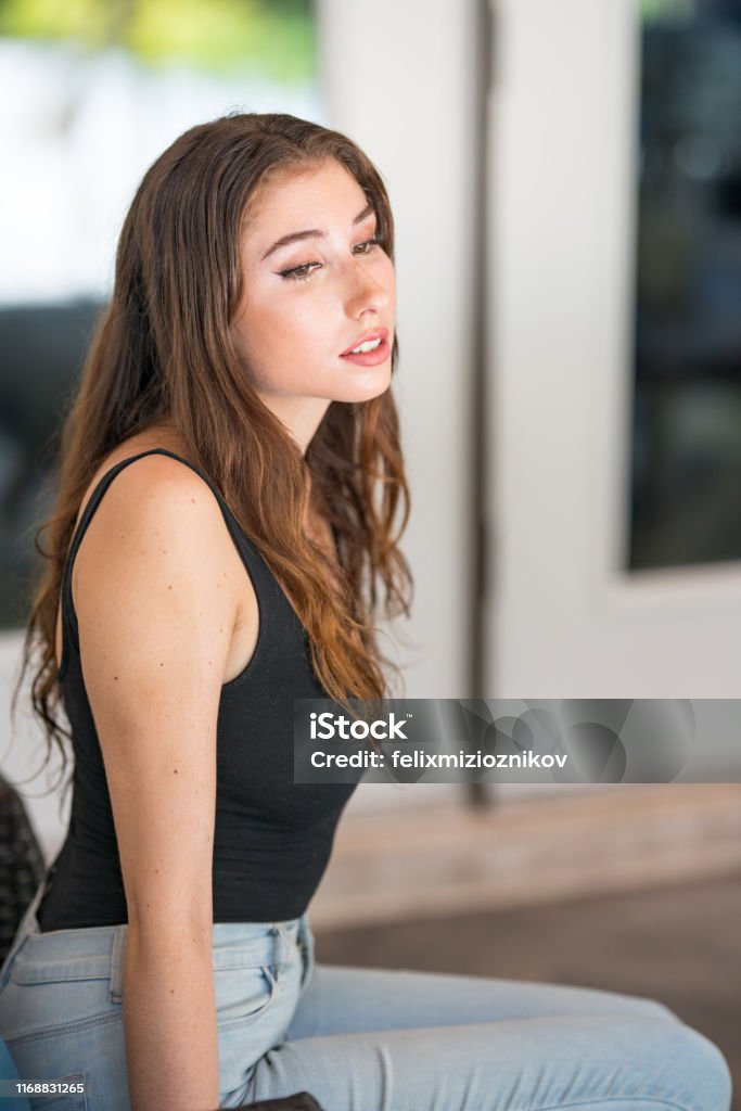 Dreamy Young Woman Relaxing Outdoors Glancing Away From Camera Stock