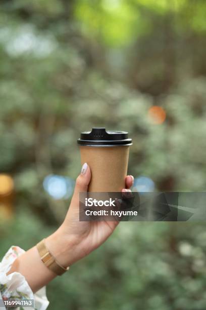Wanita Muda Tangan Memegang Cangkir Kopi Kertas Coklat Dengan Latar ... Wanita Muda Tangan Memegang Cangkir Kopi Kertas Coklat Dengan Latar ...