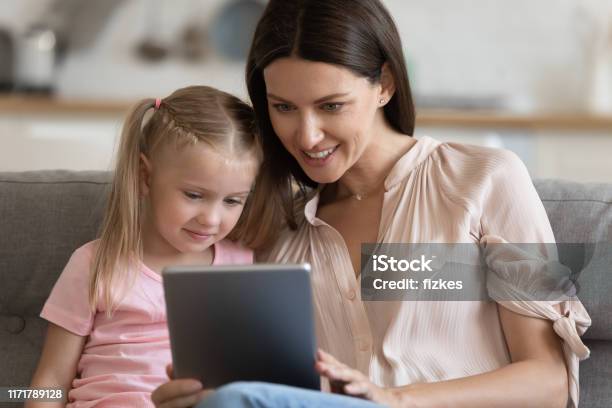 Ibu Dan Putri Kecil Duduk Di Sofa Menggunakan Tablet Foto Stok Unduh