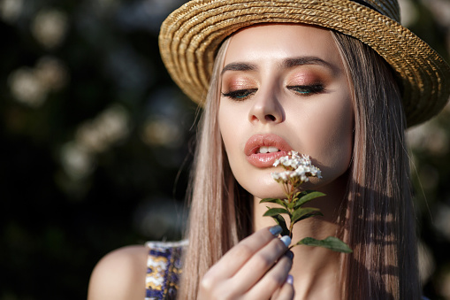 Young Beautiful Woman With A Pleasant Smile In A Straw Hat Alone In A
