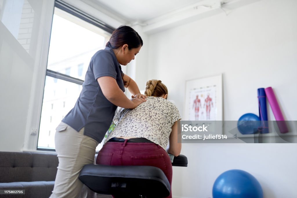 Chinese Woman Massage Therapist Giving A Neck And Back Pressure