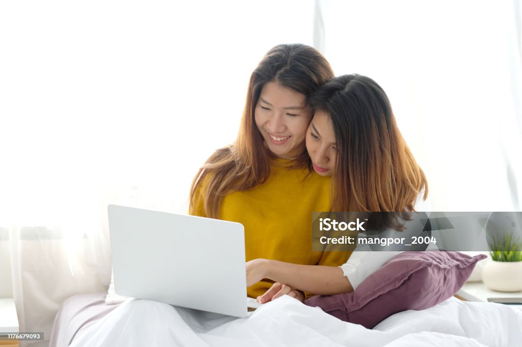 Young Cute Asia Woman Lesbian Couple Using Laptop Computer With