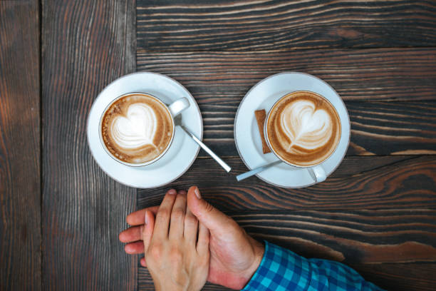 Free Stock Photo of Top view of a young lovers hand holding coffee with ...