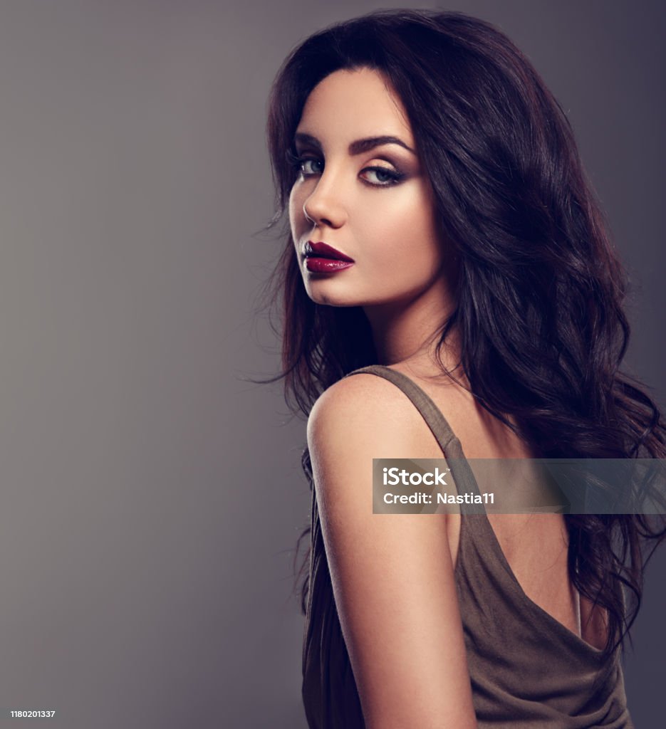 Beautiful Bright Makeup Woman With Long Black Curly Hair Style In Green