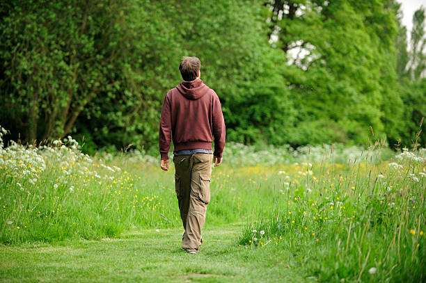 Free Stock Photo of Man Walking Across Lush Green Field | Download Free ...