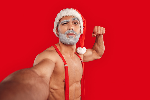 Christmas Freestyle Young Bearded Santa Claus Bare Muscular Upper Body In Hat Standing Isolated