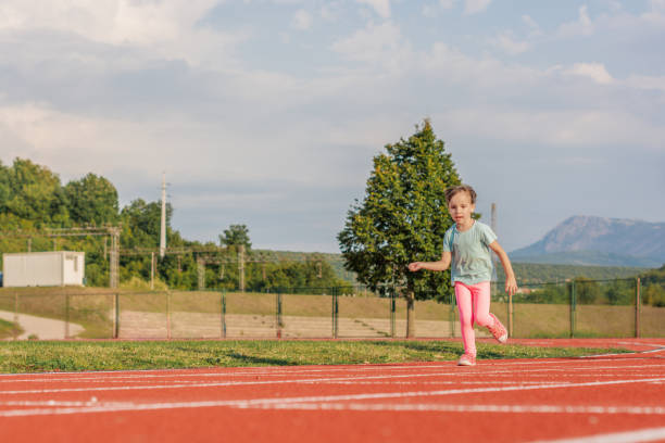 Free Stock Photo of A cute young girl running on a track field ...