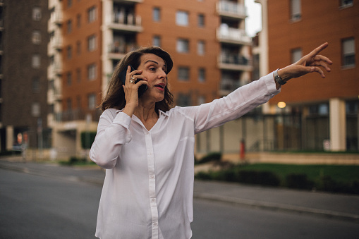 Olgun Kadın Bir Taksi Yakalamak Ve Telefonda Konuşurken Stok