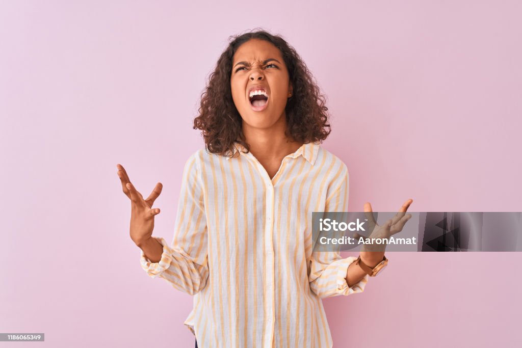 Young Brazilian Woman Wearing Striped Shirt Standing Over Isolated Pink