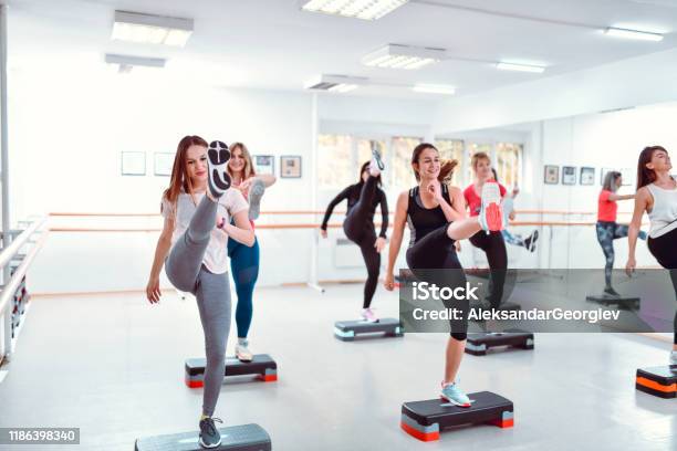 Wanita Atletik Berlatih Angkat Kaki Pada Stepper Di Gym Foto Stok