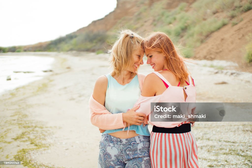 Adult Daughter And Mom Hugs On The Sea Shore And Both Are Smiling Stock