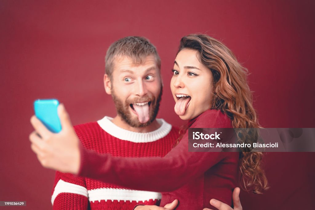 Happy Crazy Couple Taking Selfie While Doing Silly Face With Mobile
