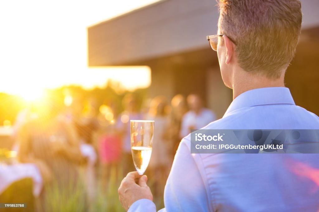 Businessman Drinking Champagne And Celebrating Success With Colleagues