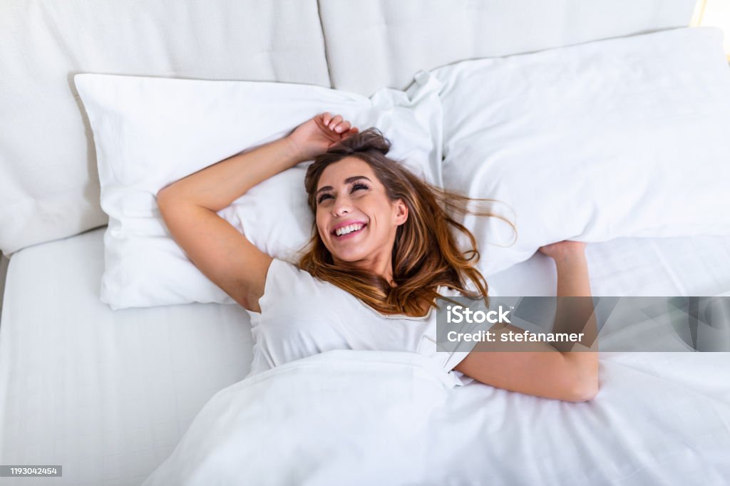 Beautiful Woman Waking Up In Her Bed She Is Smiling And Stretching
