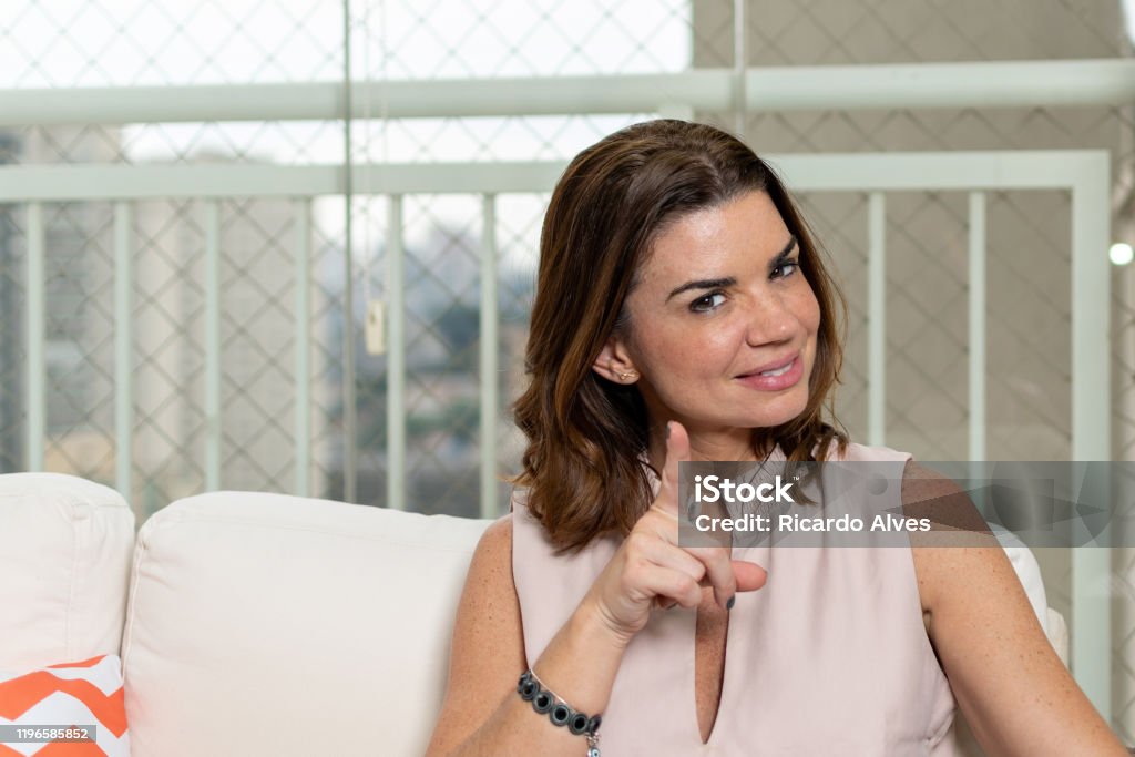 38 Year Old Woman In Her Home Office Looking At The Camera And Pointing