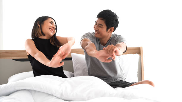 Attractive Woman Waking Up In Morning With Her Husband Sleeping Stock