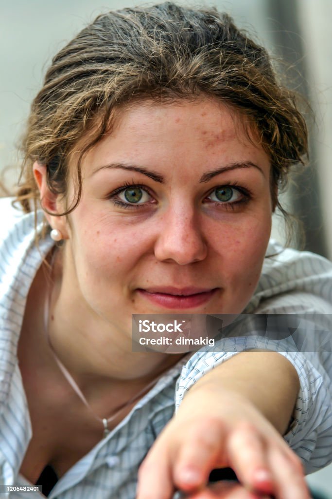 Portrait Of A Young Woman Wearing White Shirt Looking At Camera Stock