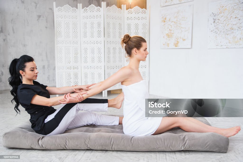 Young Woman Getting Traditional Thai Stretching Massage By Therapist