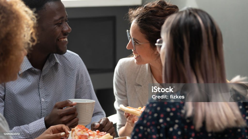 Happy Diverse Coworkers Have Fun Spending Lunch Break Together Stock