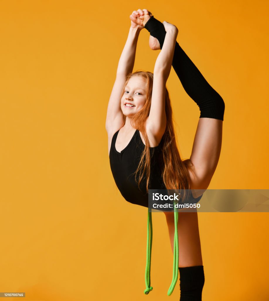 Flexible Redhead Girl Gymnast In Swimsuit And Stockings Is Stretching