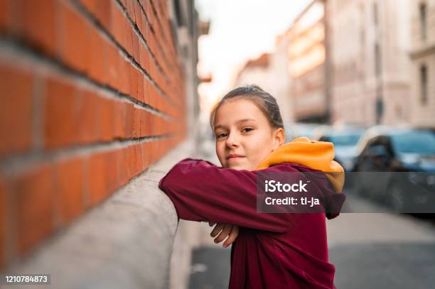Gadis Kecil Bersandar Di Dinding Bangunan Di Jalan Kota Foto Stok Unduh Gambar Sekarang Istock