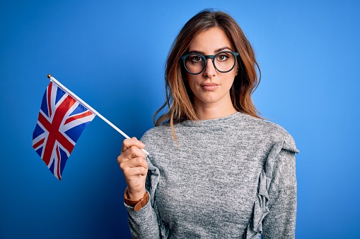 Wanita Patriotik Brunette Cantik Muda Memegang Bendera Kerajaan Bersatu ... Wanita Patriotik Brunette Cantik Muda Memegang Bendera Kerajaan Bersatu ...