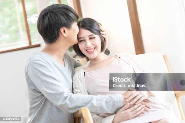 Ibu Hamil Ceria Duduk Di Sofa Ayah Mencium Dahi Melihat Keluar Jendela