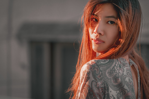 Asian Chinese Woman With Tanned Beauty Skin Portrait In A Green Garden