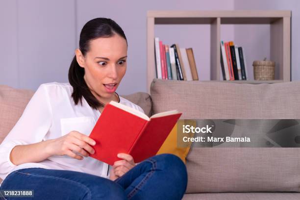 Wanita Berambut Cokelat Cantik Muda Terkejut Membaca Buku Yang Duduk Di