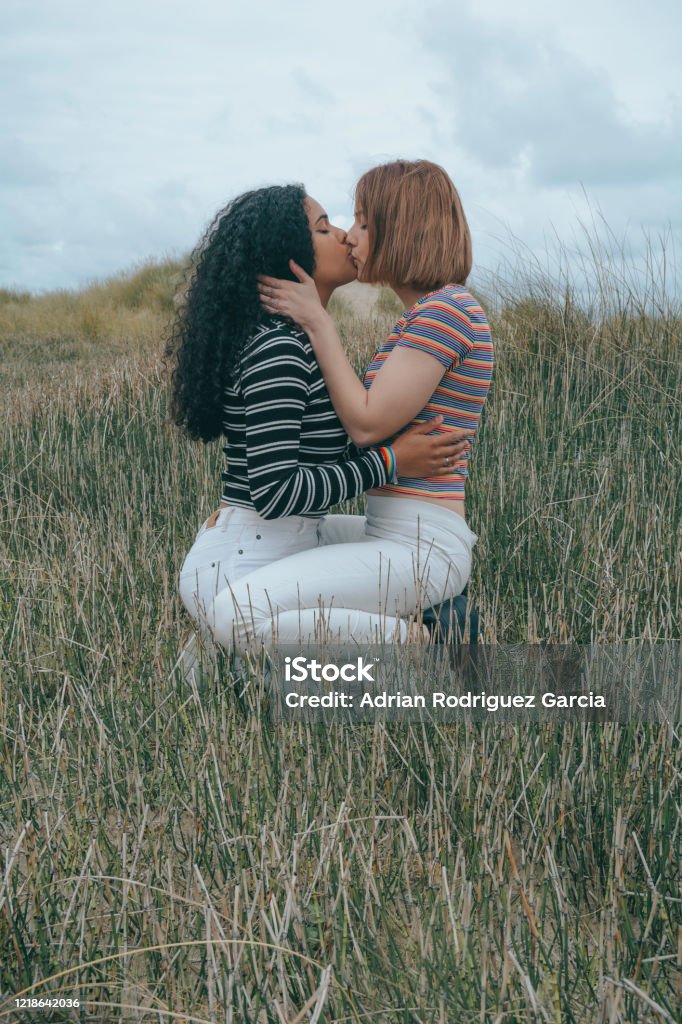 Two Lesbian Women Kissing On Top Of Each Other One Girl Is Latino And
