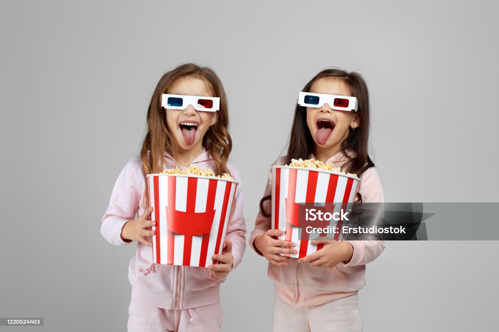 Dua Gadis Kecil Dengan Kacamata 3d Merahbiru Memegang Ember Popcorn ... Dua Gadis Kecil Dengan Kacamata 3d Merahbiru Memegang Ember Popcorn ...