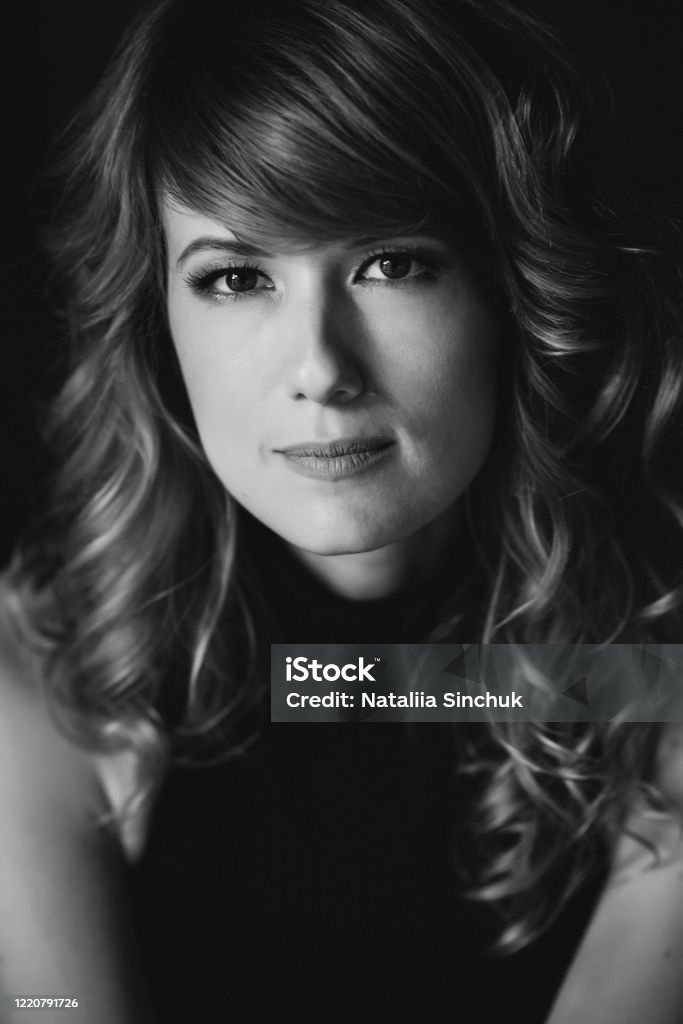 Portrait Of A 36 Year Old Woman With Curly Hair And Brown Slanting Eyes