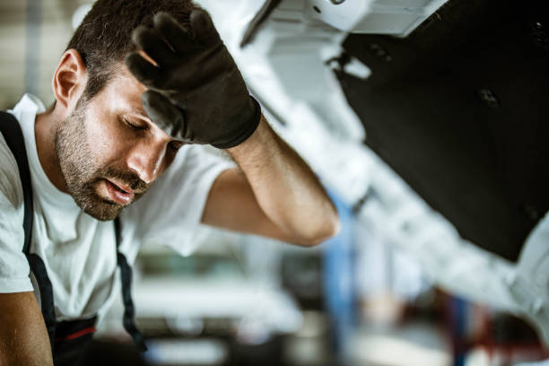 Free Stock Photo of Tired mechanic wiping sweat in auto shop | Download ...