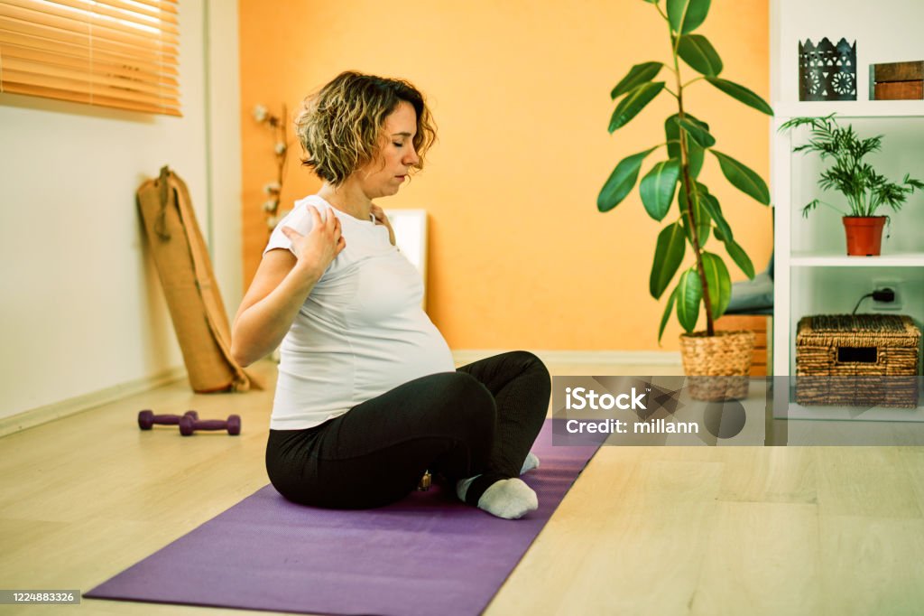 Middle Aged Pregnant Woman Sitting On The Mat In The Morning And