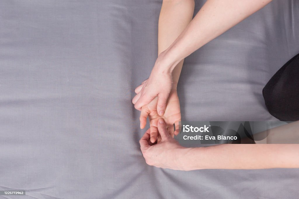 Young Woman Lying Down While Enjoying The Acupressure Techniques Of Traditional Thai Massage At