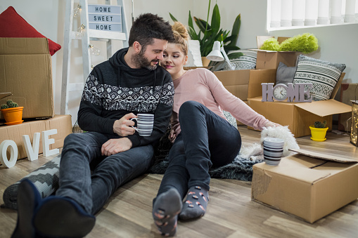 Young Couple Carrying Big Cardboard Box At New Homemoving House Stock