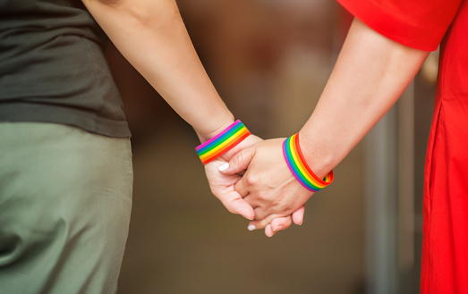 Hand Of Lgbt Women Holding Together With Rainbow Ribbon Symbol Stock