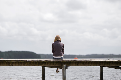Photo Libre De Droit De Une Jeune Femme Sasseyant Seule Sur Le Bord De