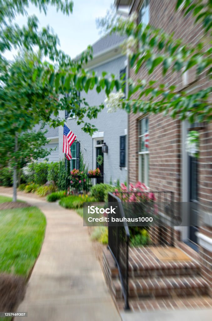 Front Porch Of A House With An American Flag Featuring Small Town