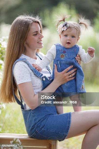 Mother And One Year Old Daughter Have Fun Together In A Green Park In