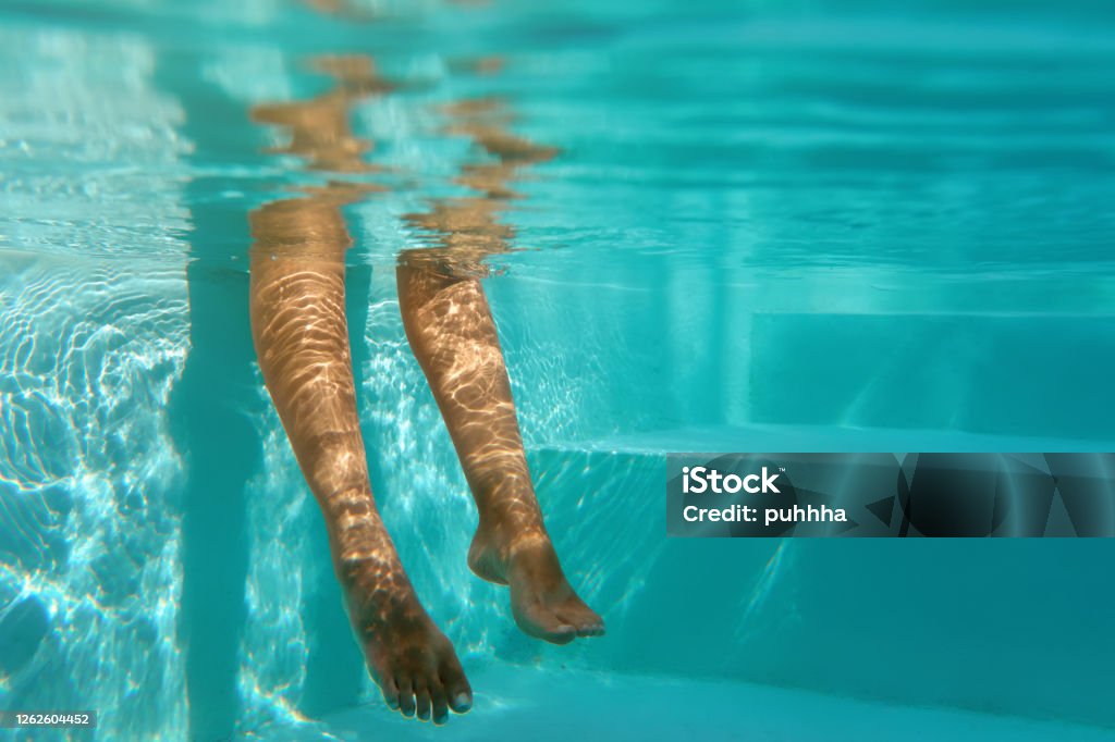 Underwater Woman Keeping Legs In Pool While Sitting On Poolside Female