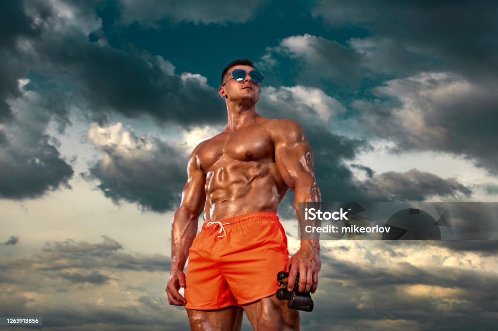 Fit Athlete Bodybuilder With Binoculars In Hand On The Beach Attractive