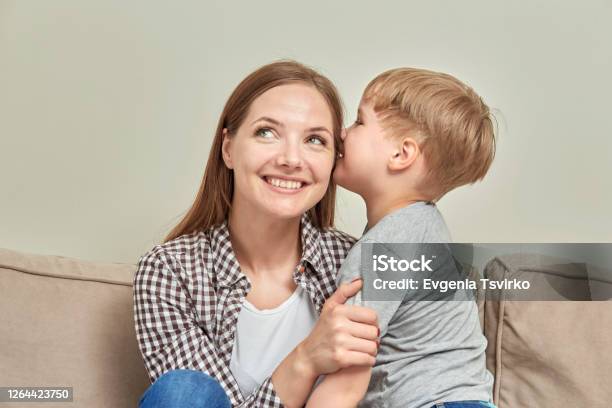 Foto De O Filho Do Menino Beija Sua Mãe Feliz E Sorridente Na Bochecha Uma Família Amorosa E