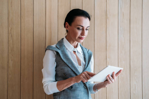 Free Stock Photo of Woman reading tablet in front of wooden wall ...