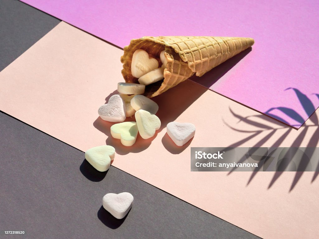 보라색 크림 회색 레이어드 페이퍼 배경에 아이스크림 와플 콘의 설탕 하트 가을 색상 팔레트 따뜻하고 활기찬 야자 수 잎에서